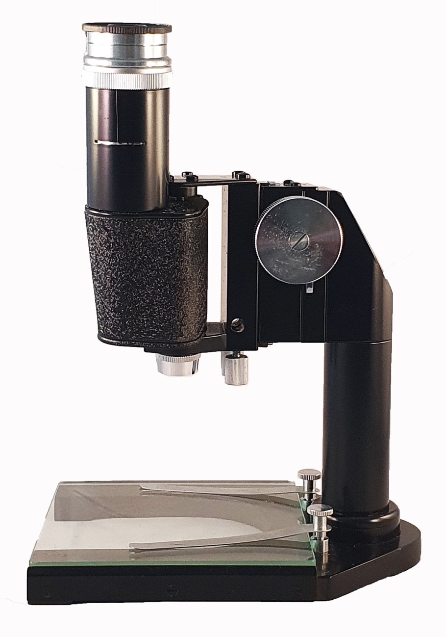 A black microscope with a white backgroundDescription automatically ...