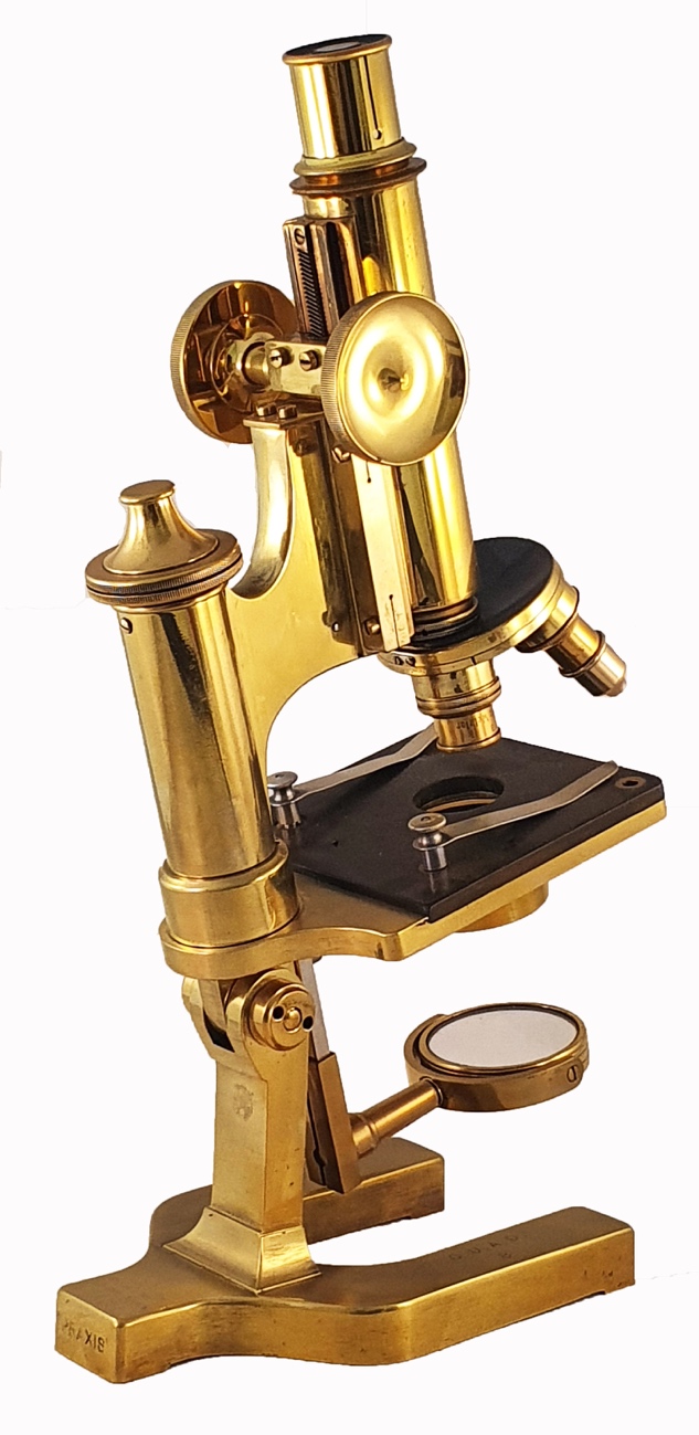 A gold microscope with a black coverDescription automatically generated